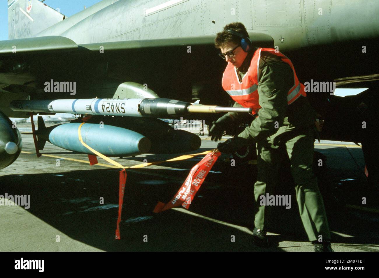 An airman secures safety streamers around Mark 82 500-lb. practice ...