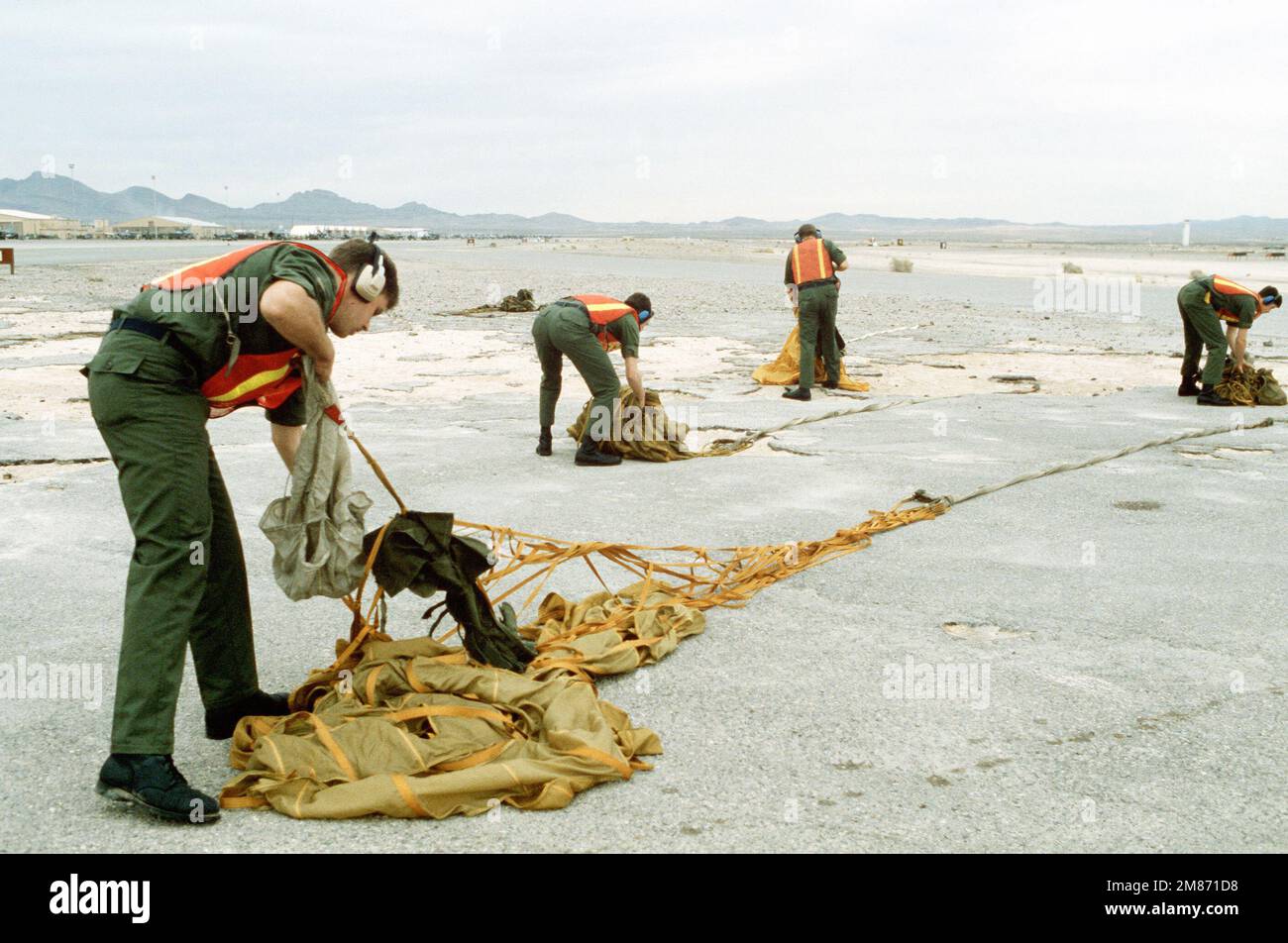 Ground crew members roll up drag chutes during exercise Red Flag '87 ...