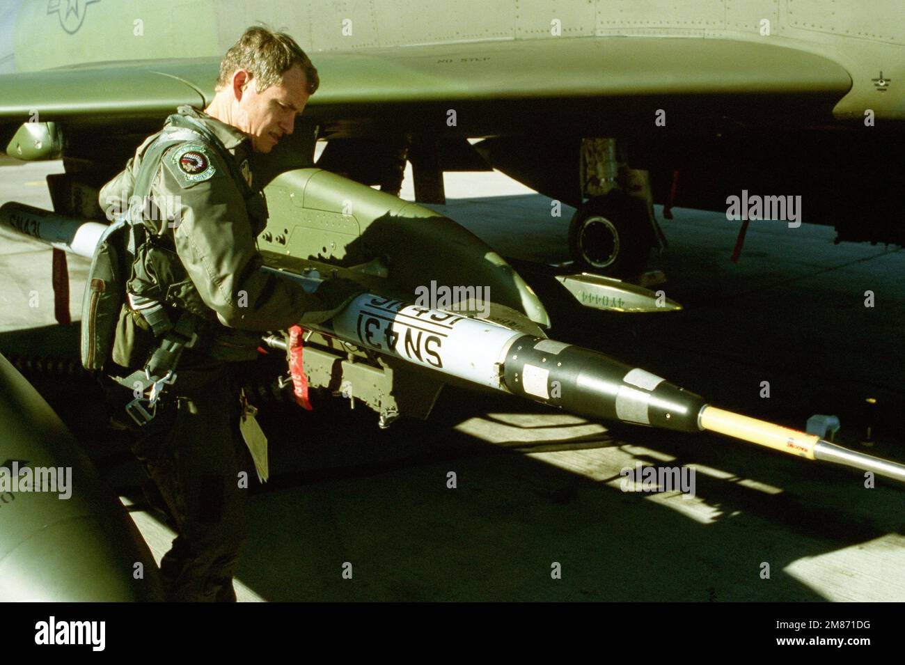 MAJ Sidney Thurston inspects an airborne telemetry pod on the pylon of ...