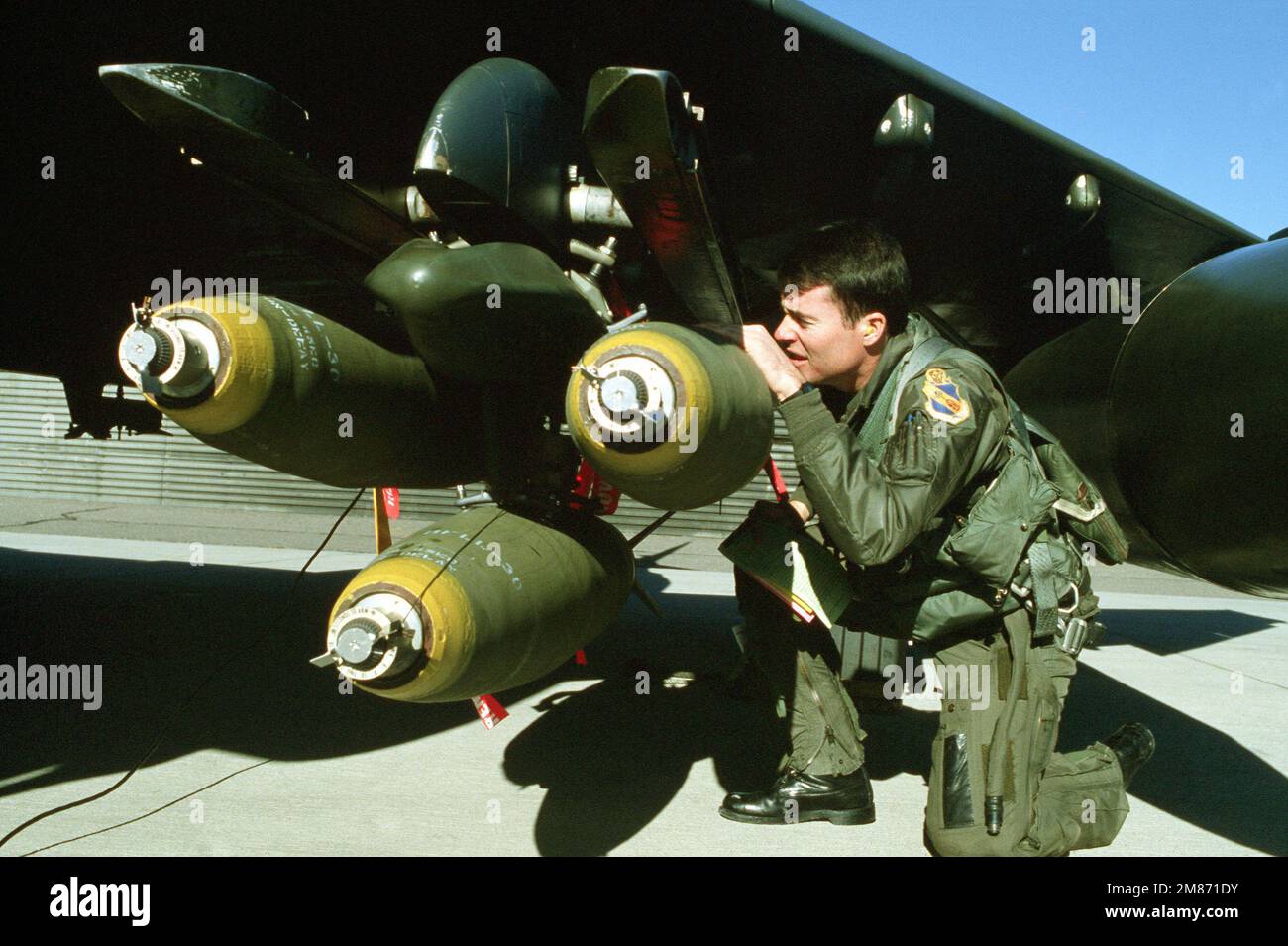 1LT Gary Olsen inspects Mark 82 500-lb. bombs on the pylon of a 335th ...