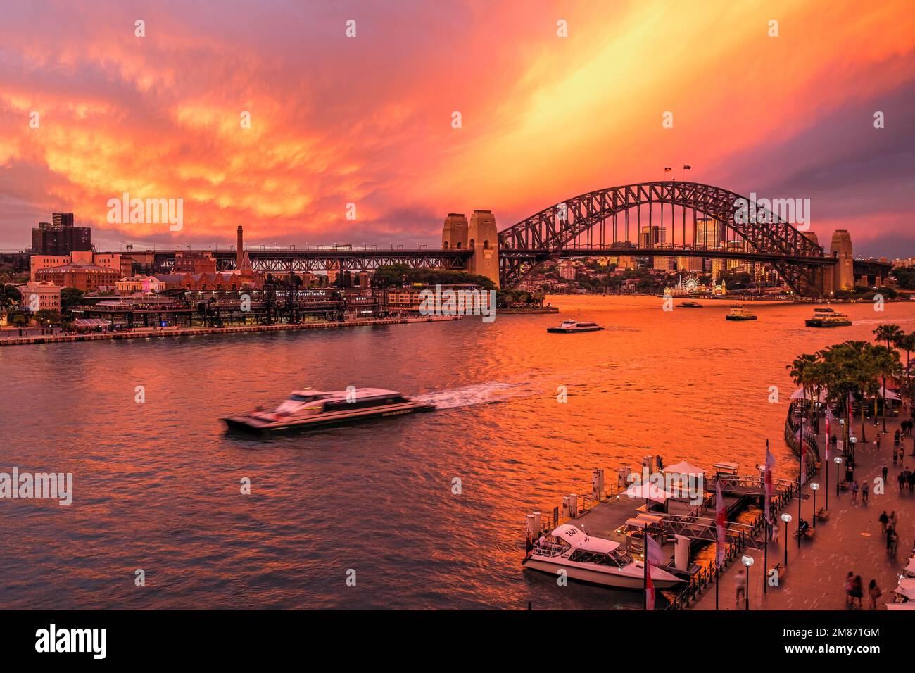 Dramatic sunset over the Sydney Harbour Bridge in Australia as ferries ...