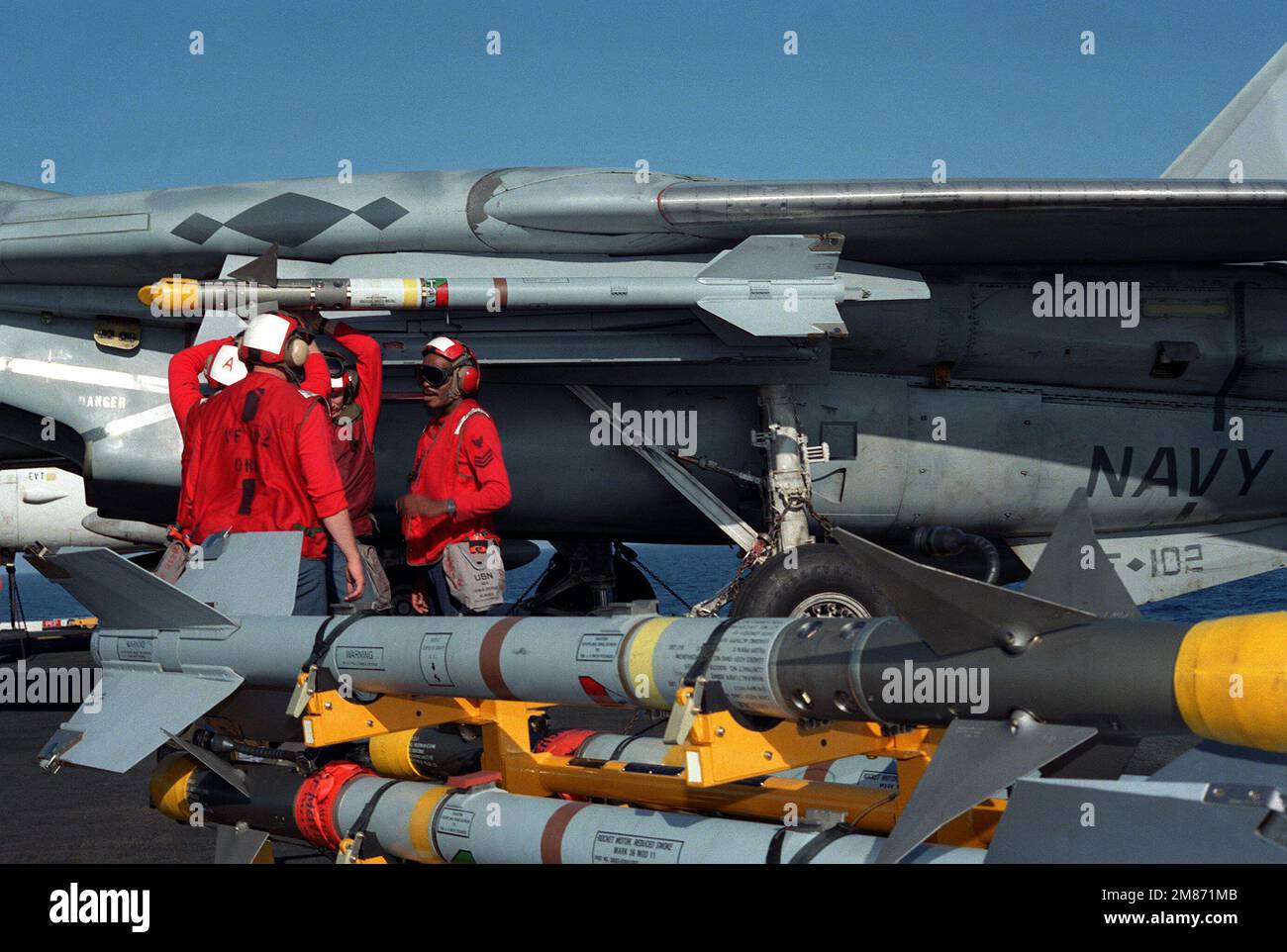 Ordnancemen mount an AIM-9 Sidewinder missile onto a Fighter Squadron ...