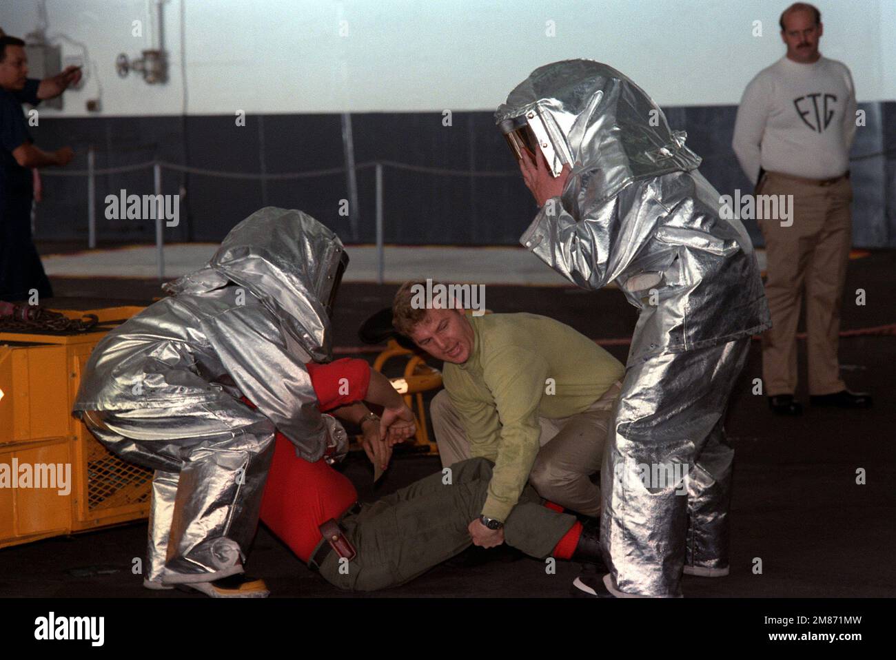 Crew members dressed in proximity suits come to the aid of a simulated ...