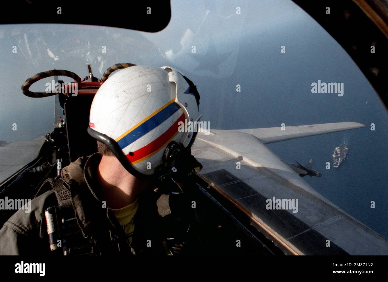 The radar intercept officer aboard a Fighter Squadron 2 (VF-2) F-14A Tomcat aircraft glances ...