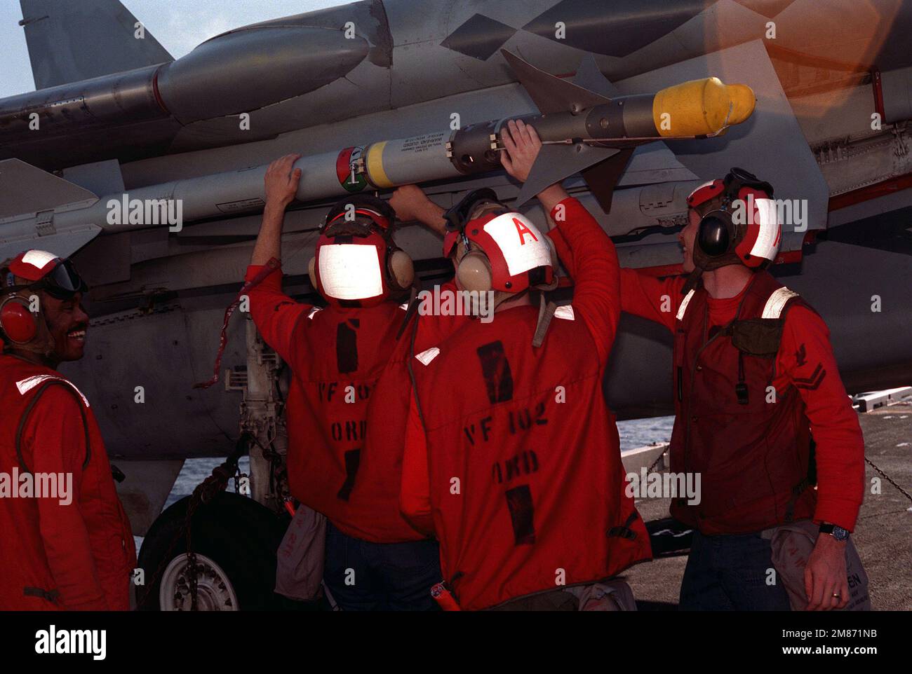 Ordnancemen mount an AIM-9 Sidewinder missile onto a Fighter Squadron ...