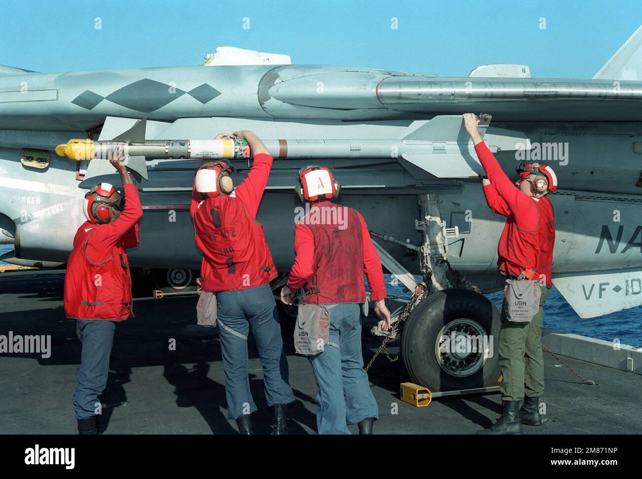 Ordnancemen mount an AIM-9 Sidewinder missile onto a Fighter Squadron ...