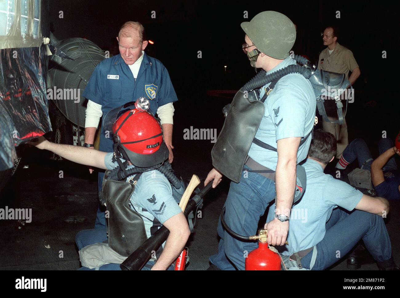 Crew members wearing oxygen breathing apparatus practice firefighting ...