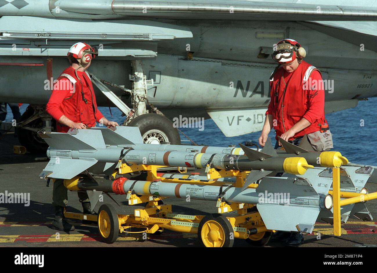 Ordnancemen prepare to mount AIM-9 Sidewinder missiles on a Fighter ...