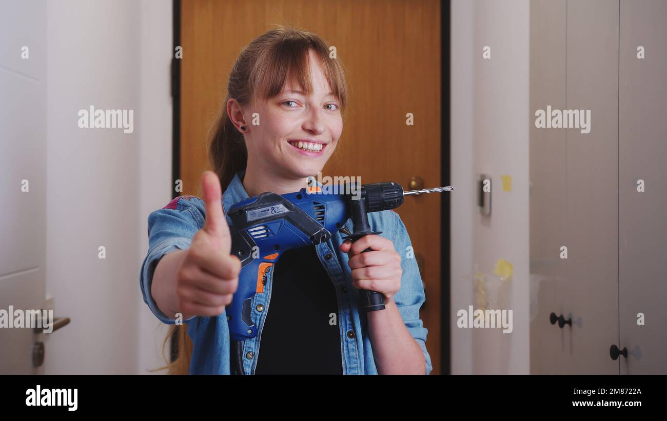 I did it, happy and satisfied woman showing thumb up and holding a ...
