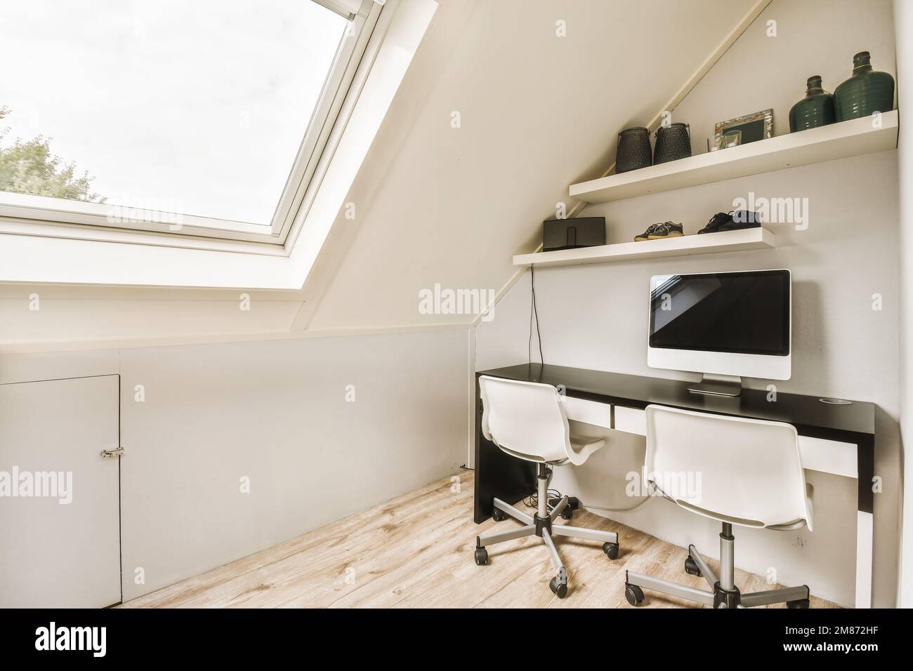 a room with a desk, computer monitor and shelves on the wall next to ...