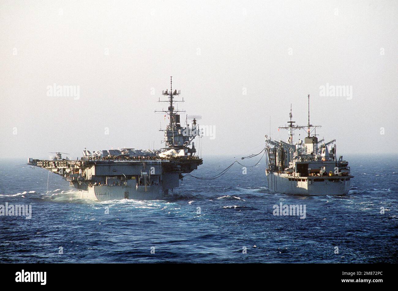 A stern view of the aircraft carrier USS SARATOGA (CV-60), left, and ...