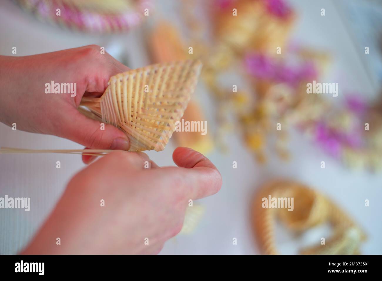 The woman's hands weave straw. traditional craft Stock Photo - Alamy