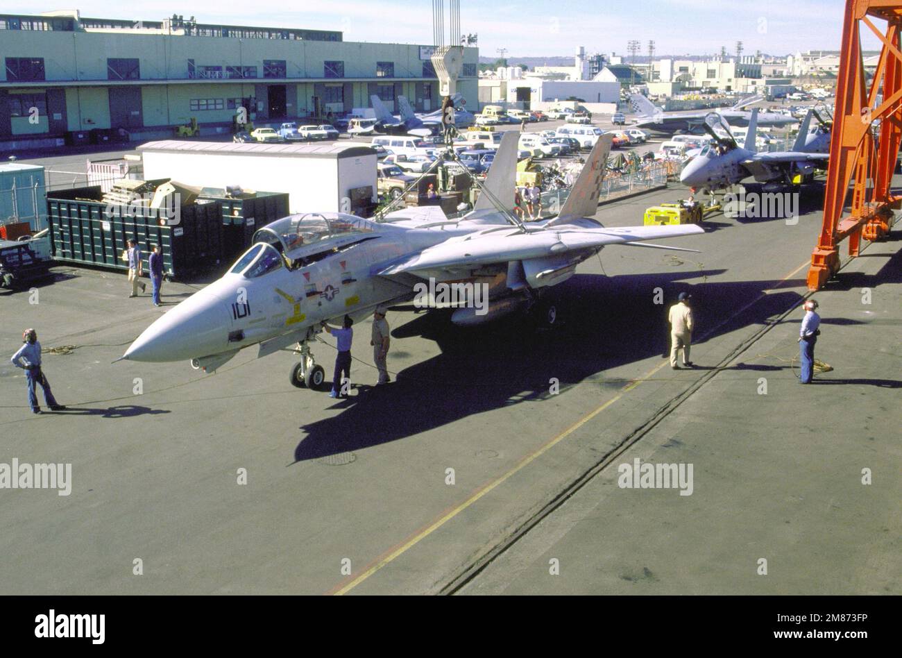 Shipyard workers check stabilizing ropes tied to the landing gear of a ...