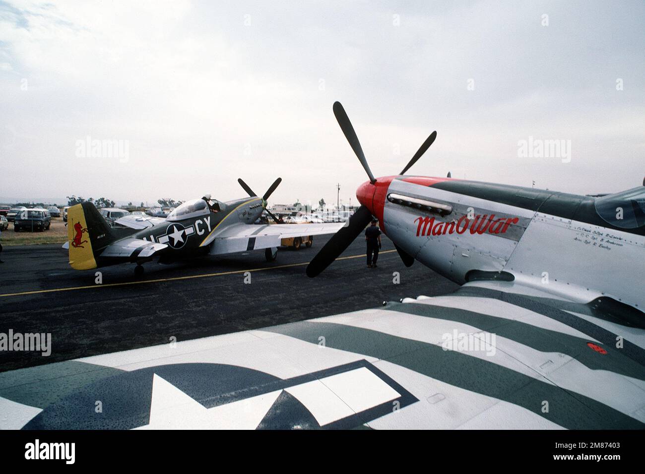 A World War II P-51 Mustang aircraft is towed across the flight line ...