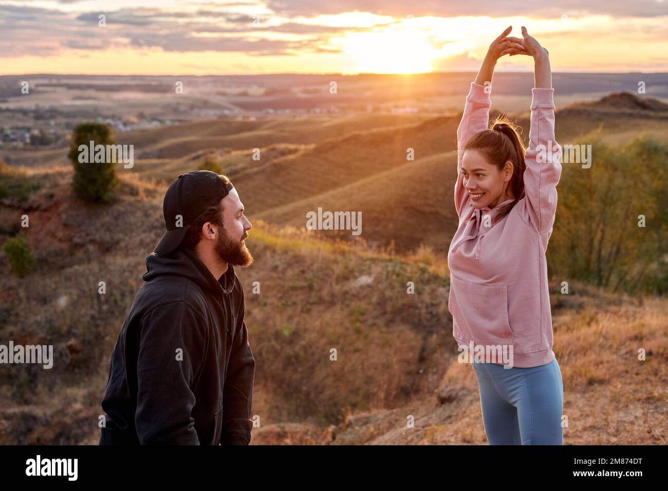Fit couple stand opposite to each other training, exercising outdoors ...