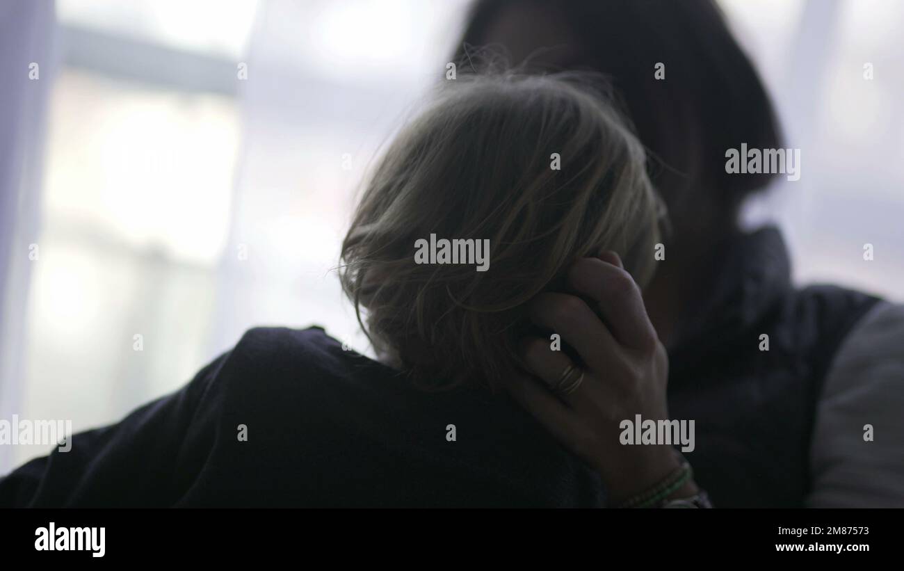 Mother caressing baby toddler hair next to window looking out Stock ...