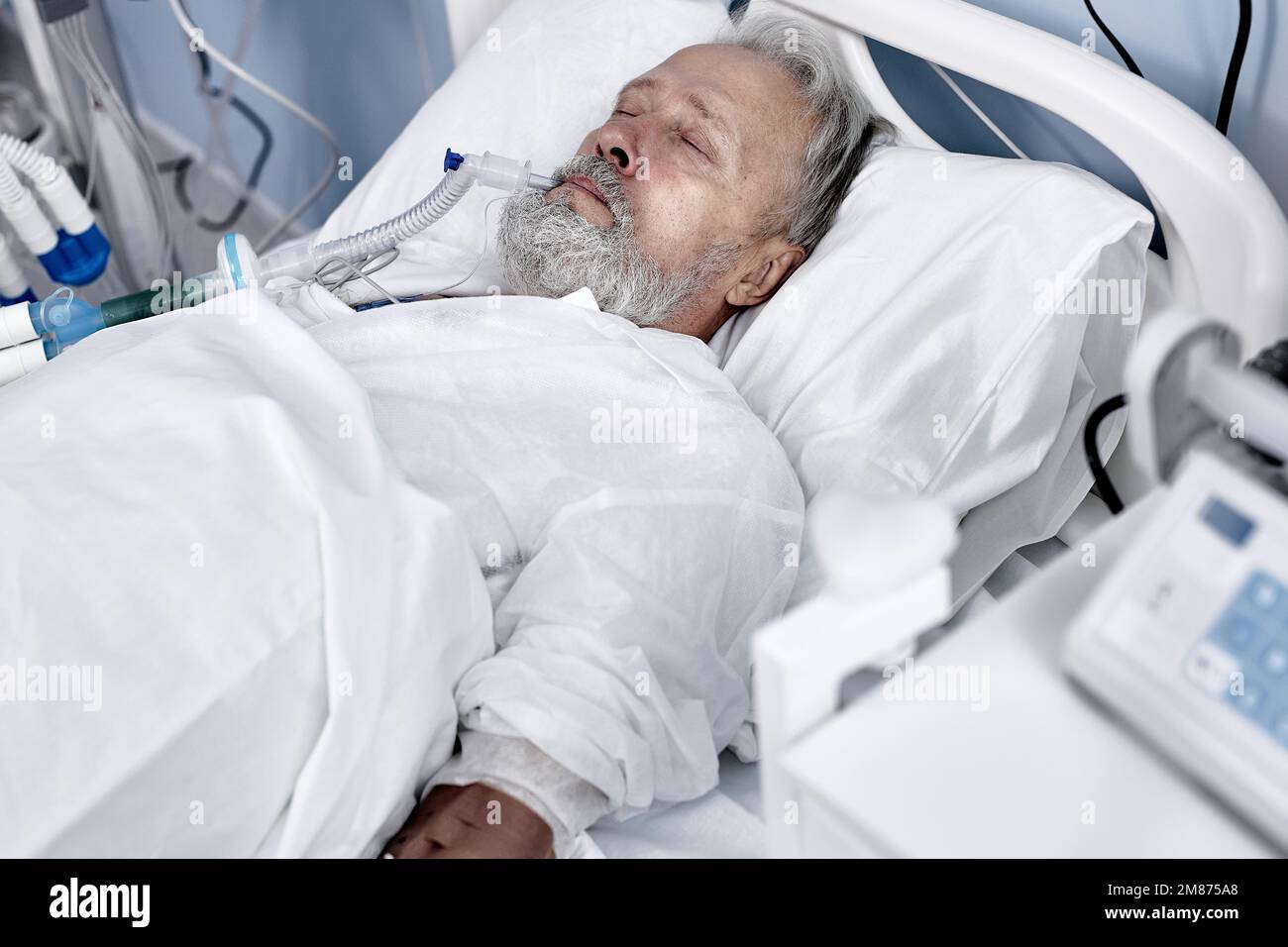 caucasian senior man patient lying on bed at hospital ward. Lonely old ...