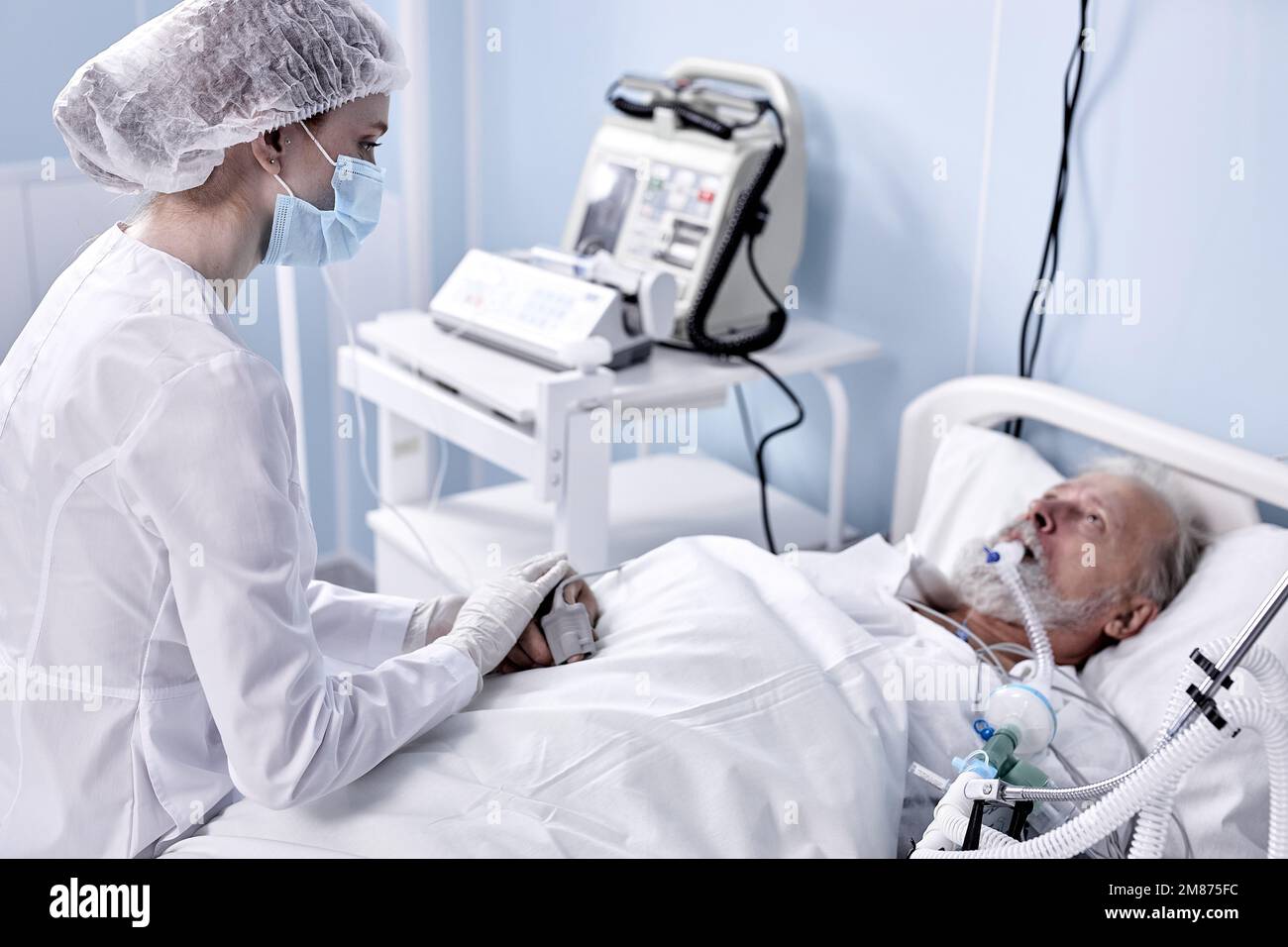 female doctor or nurse caring of senior male patient in modern hospital ...