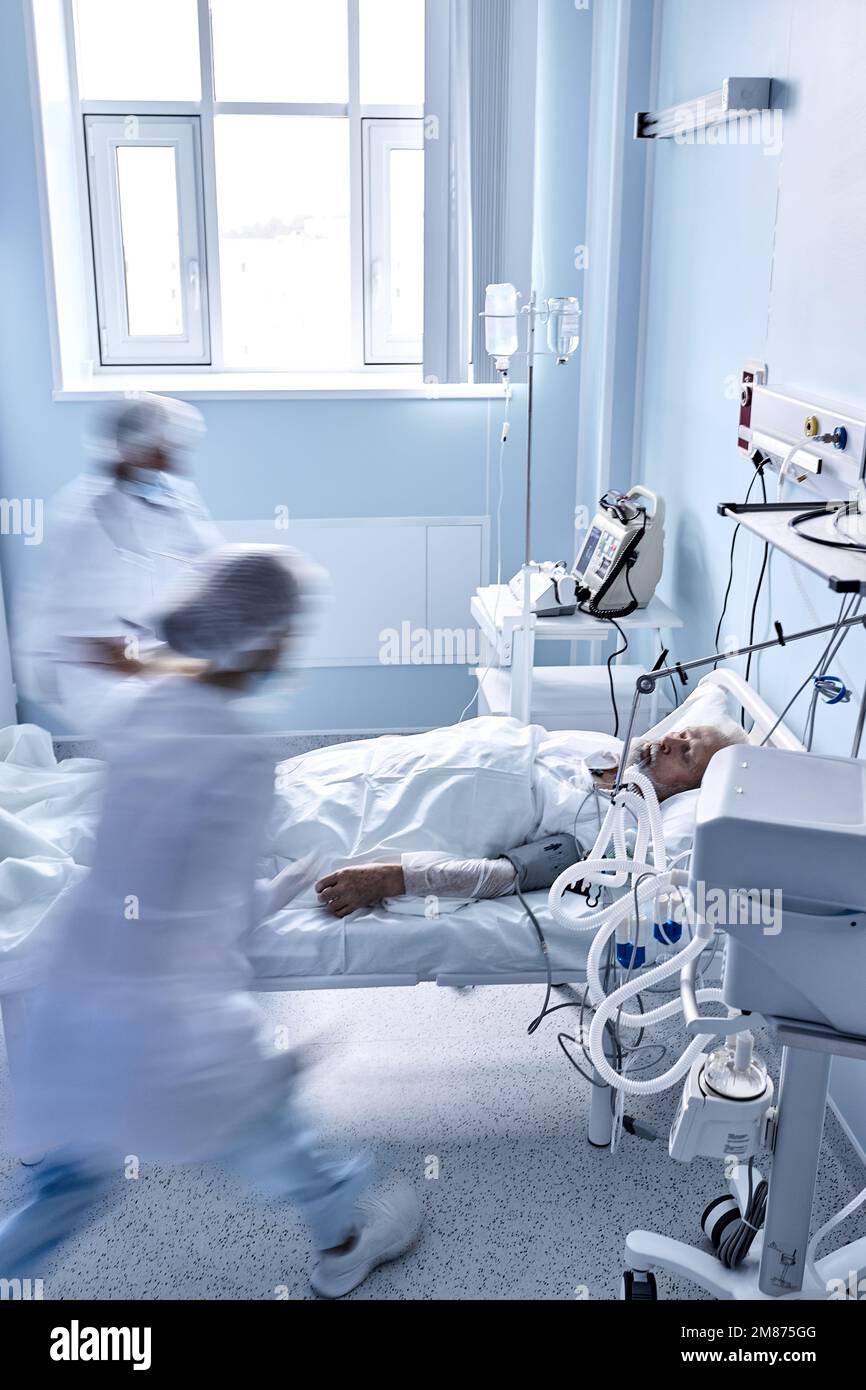 doctors run around the ward trying to help dying patient, lying on bed ...