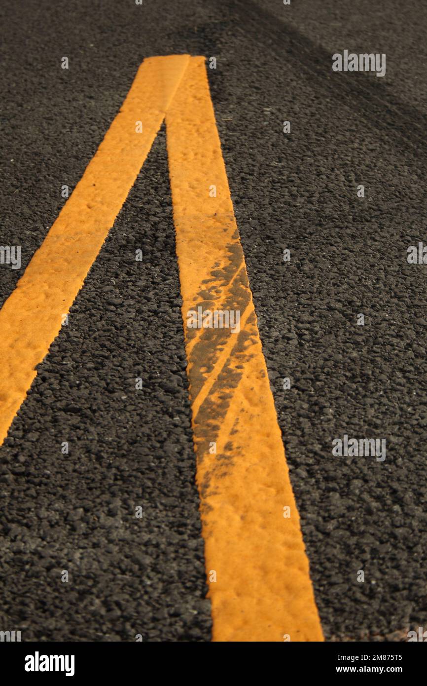 A vertical shot of yellow marking lines on an asphalt road Stock Photo ...