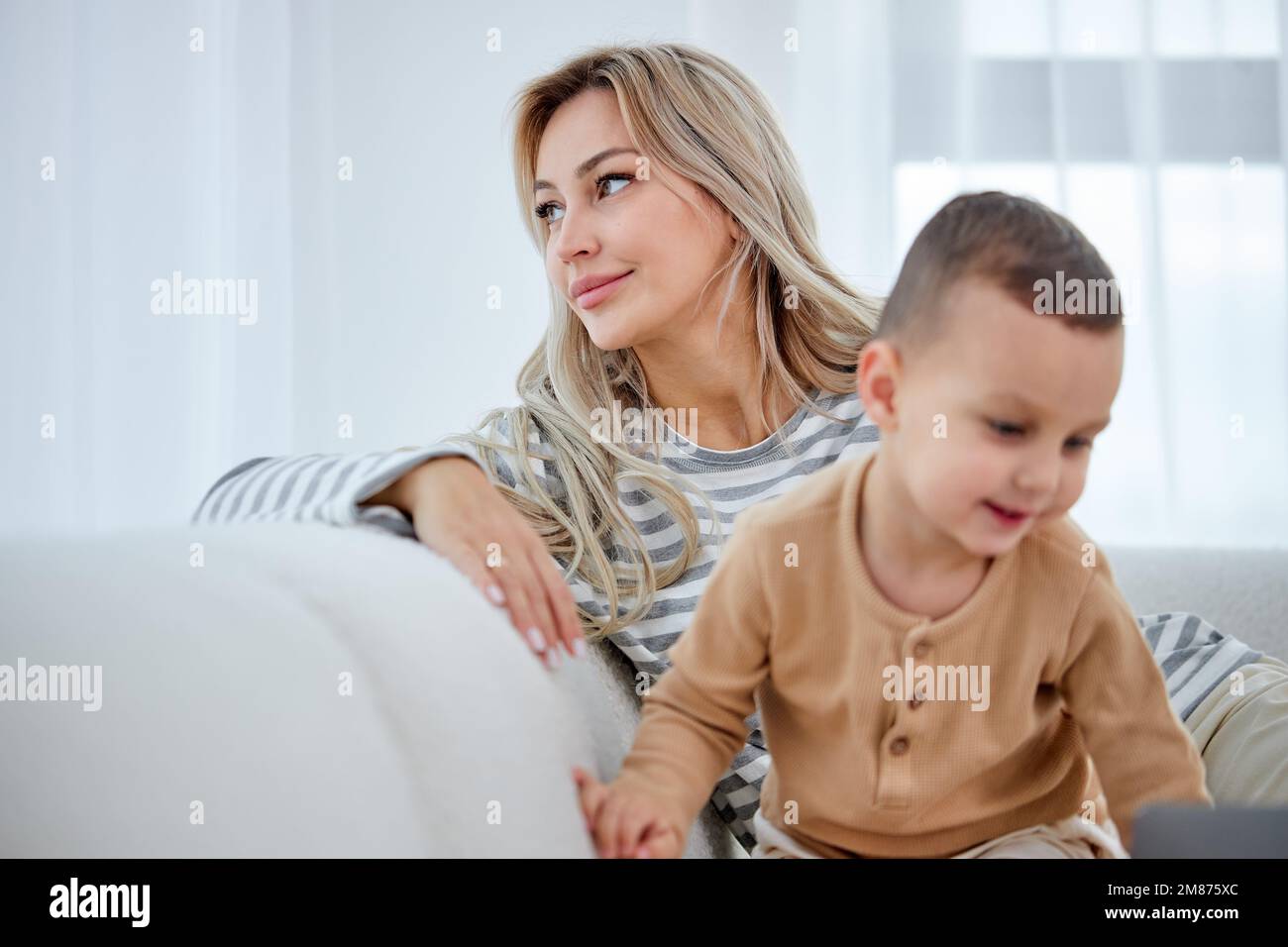 cute kid boy watching cartoons, spending time with mom at home ...