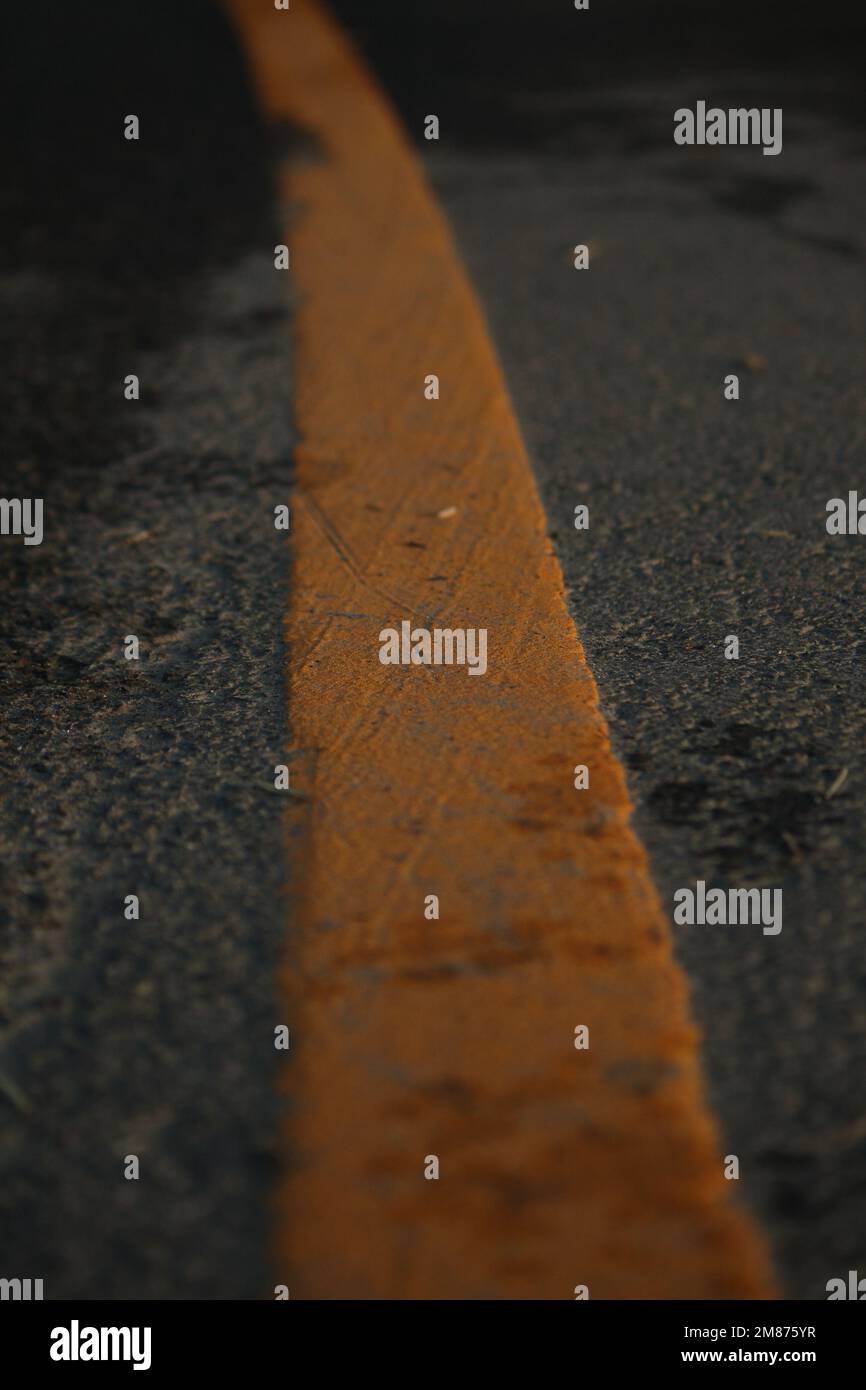 A vertical shot of a yellow marking line on an asphalt road Stock Photo ...