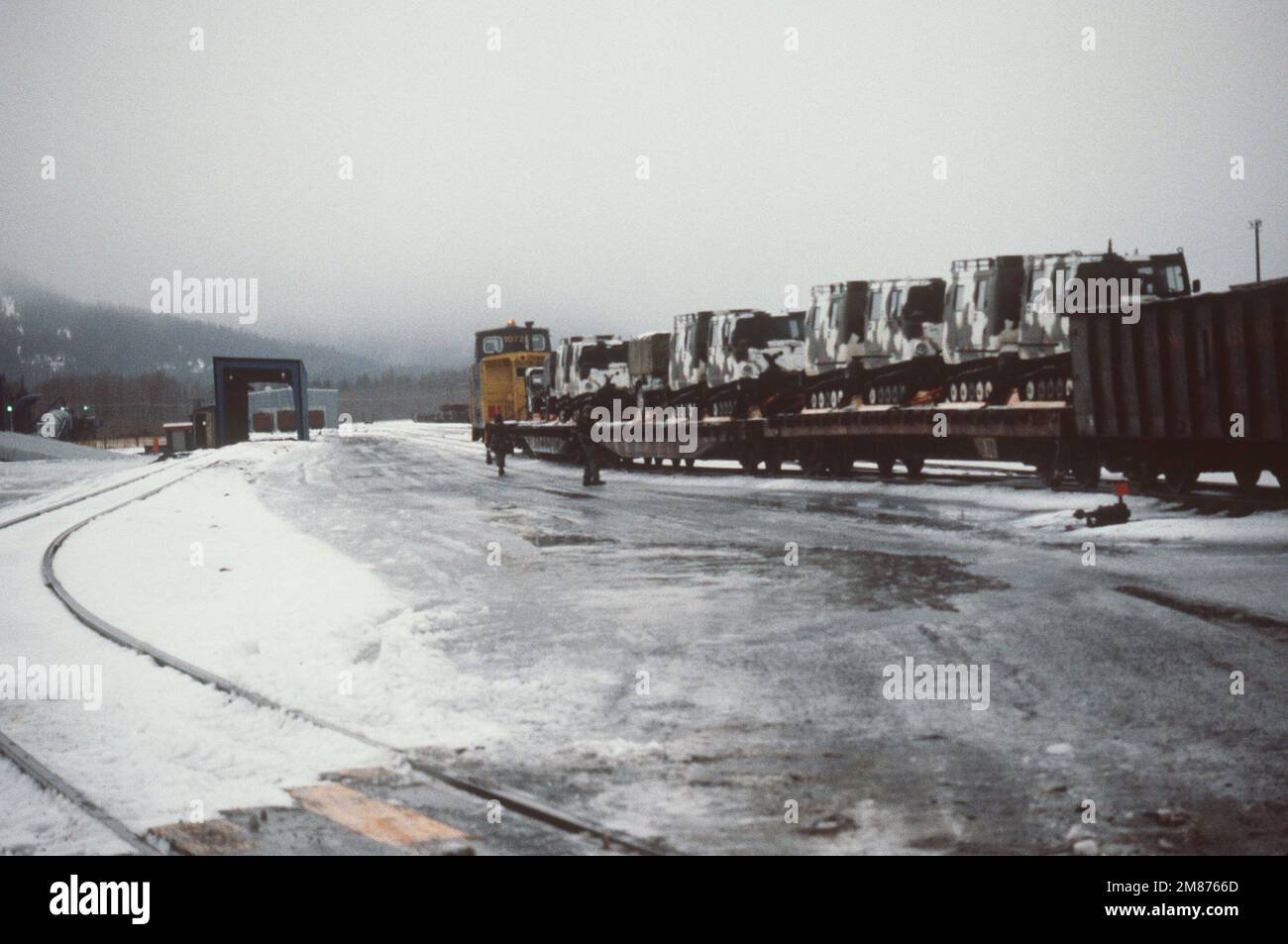 Soldiers unchain M-973 small unit support vehicles from railroad flat ...
