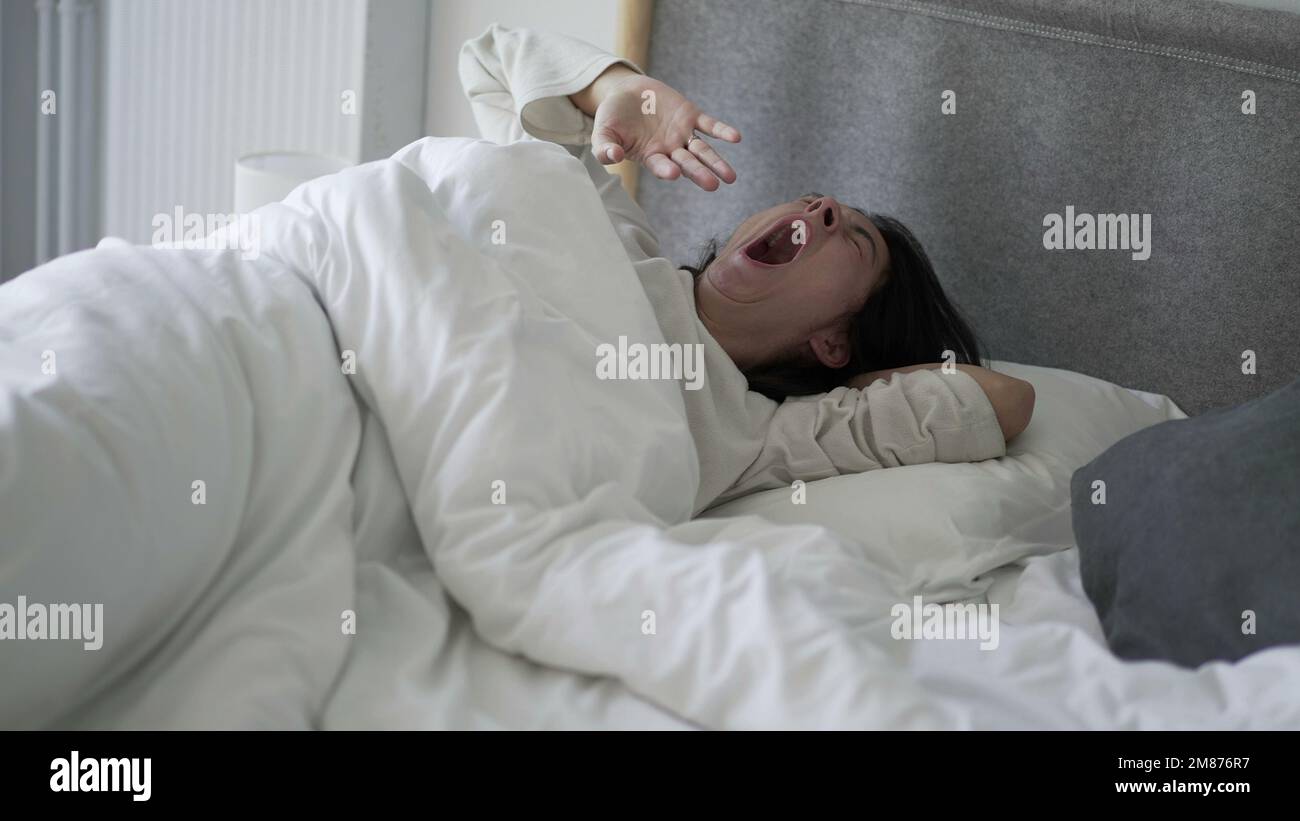 Woman yawning in the morning bed, waking up. Candid real life yawn ...