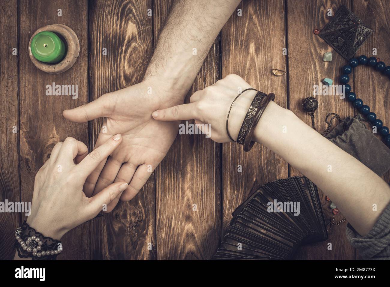 Fortune teller or oracle in search of the lines of fate in the palm of ...