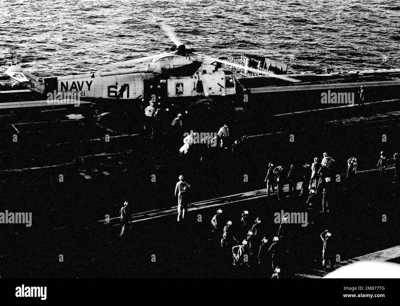 A crash victim is carried from an SH-3H Sea King helicopter of ...