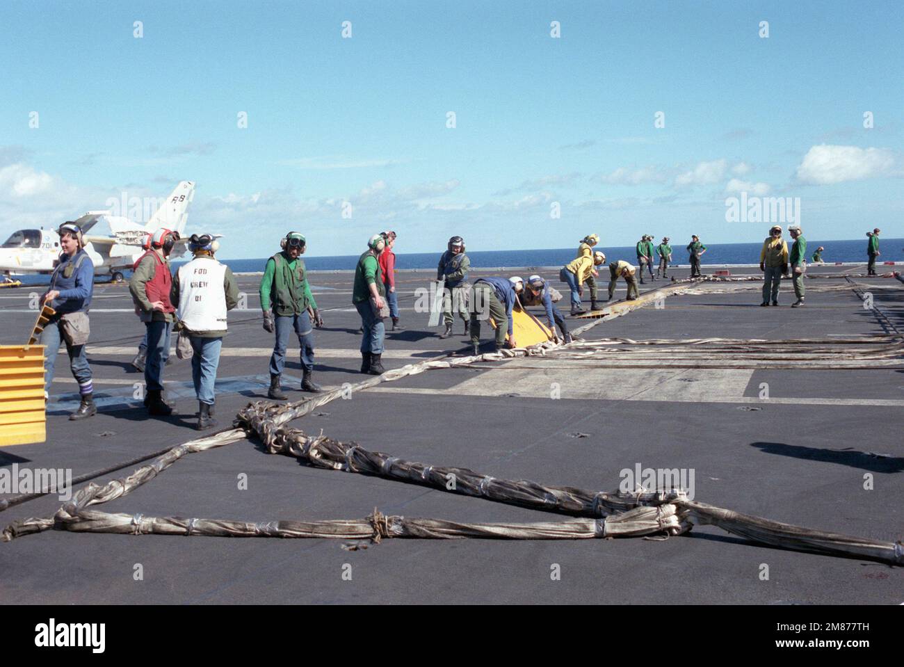Crewmen stow the crash barricade on the flight deck of the nuclear ...