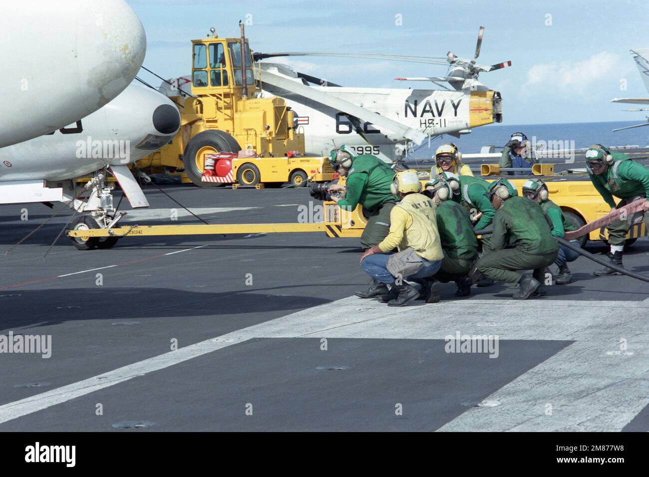 A firefighting team advances across the flight deck of the nuclear ...