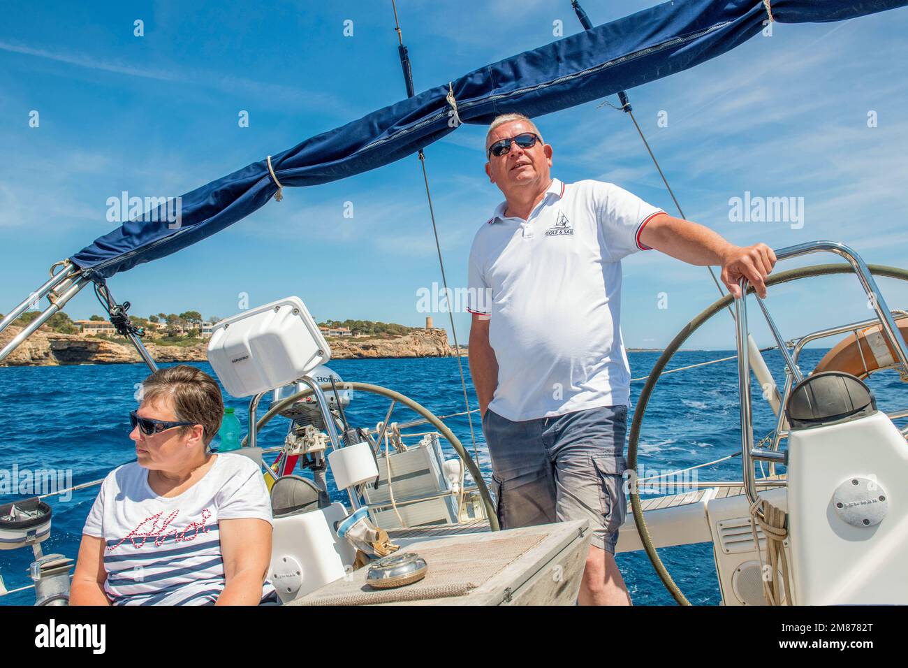 A couple is sailing a Bavaria 43 Cruiser off Porto Cristo, Mallorca ...
