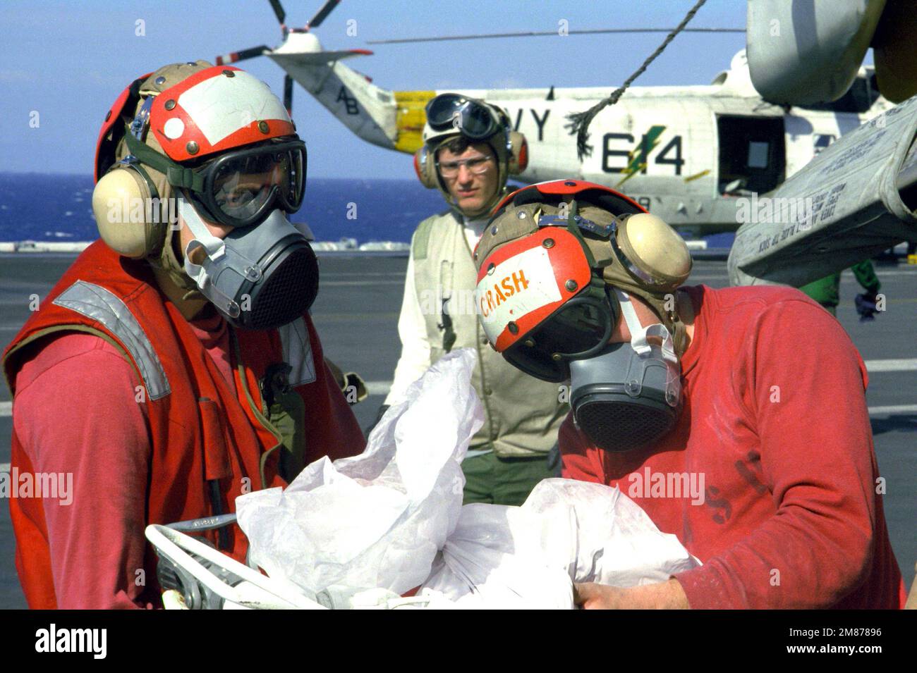Flight deck crew members wear respirators while working with chemicals aboard the nuclear ...