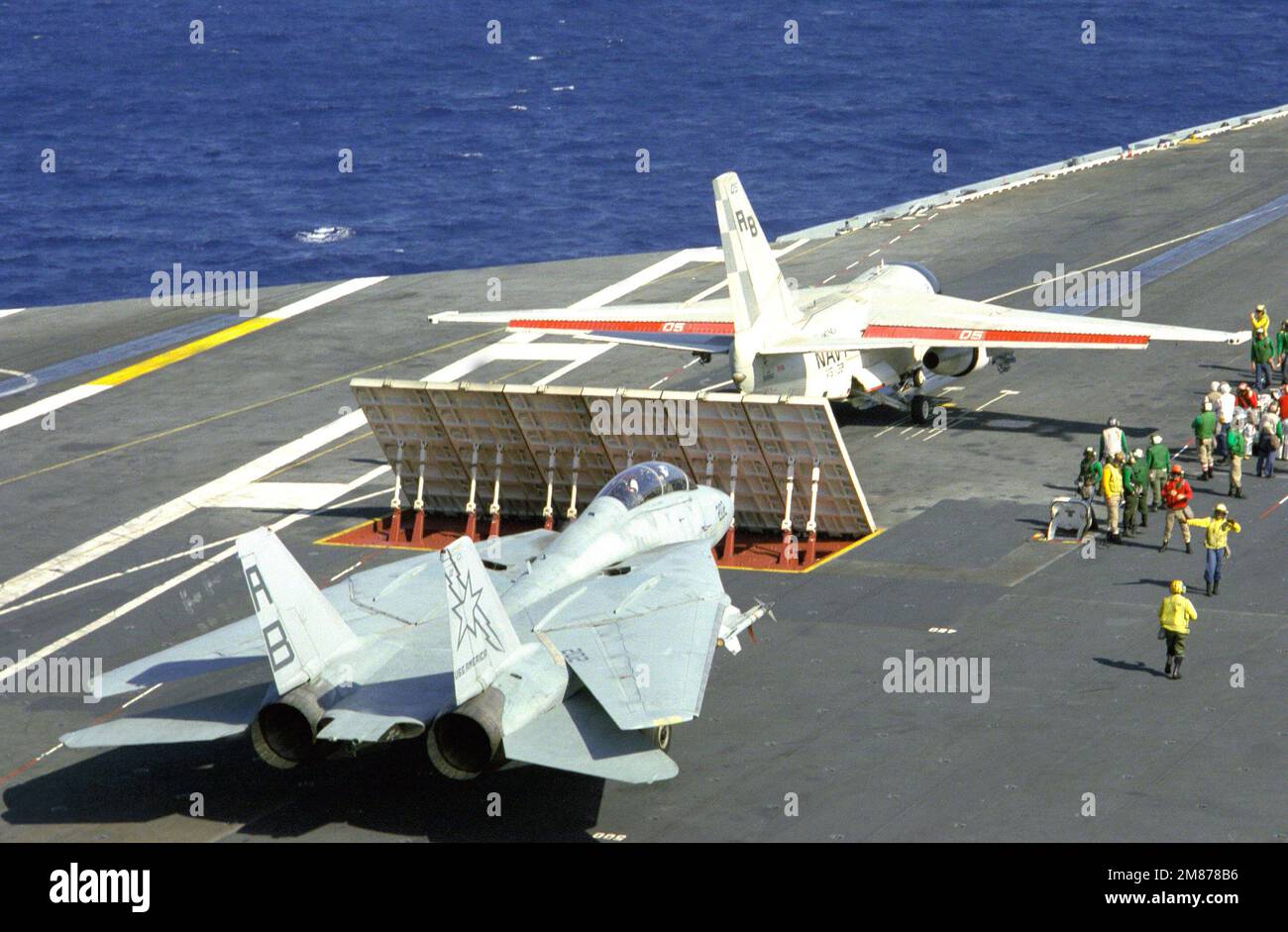 An S-3A Viking aircraft stands ready for launch as an F-14A Tomcat ...