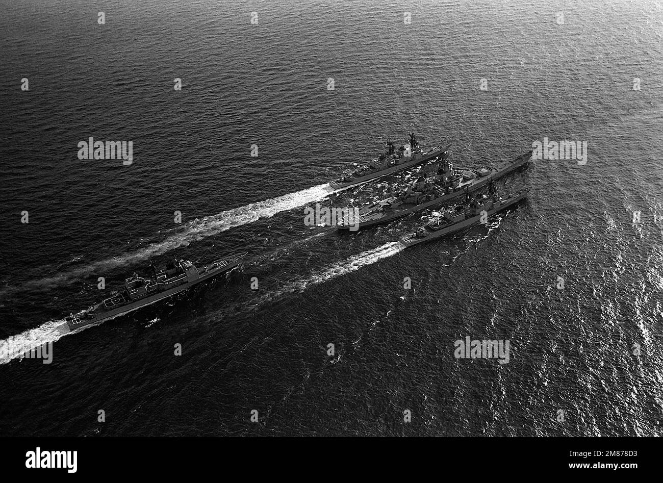 An aerial starboard quarter view of the destroyer USS DEYO (DD-989), bottom, the battleship USS ...