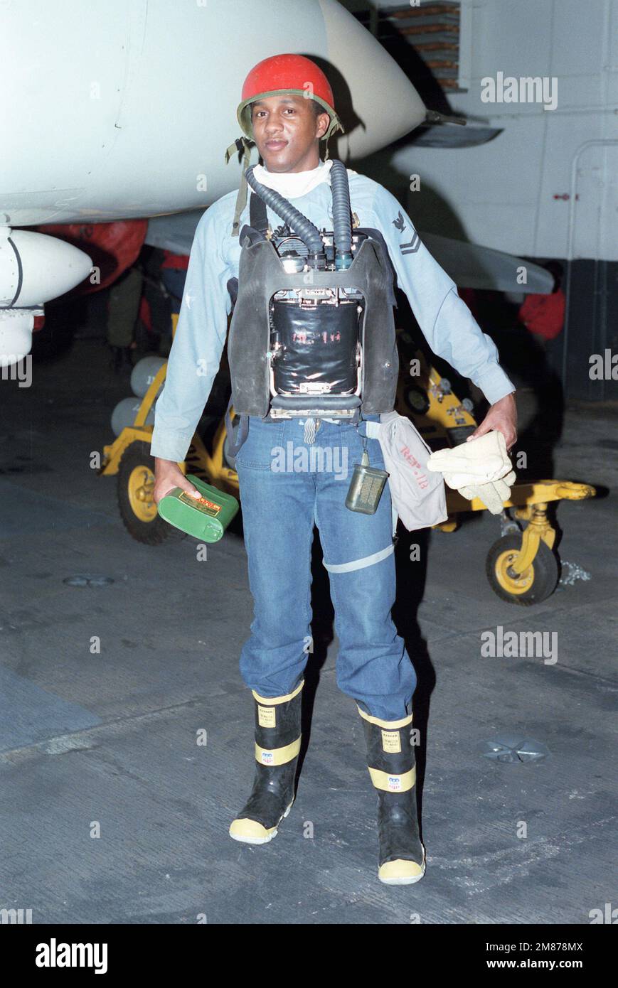 A petty officer holds the canister for his oxygen breathing apparatus ...