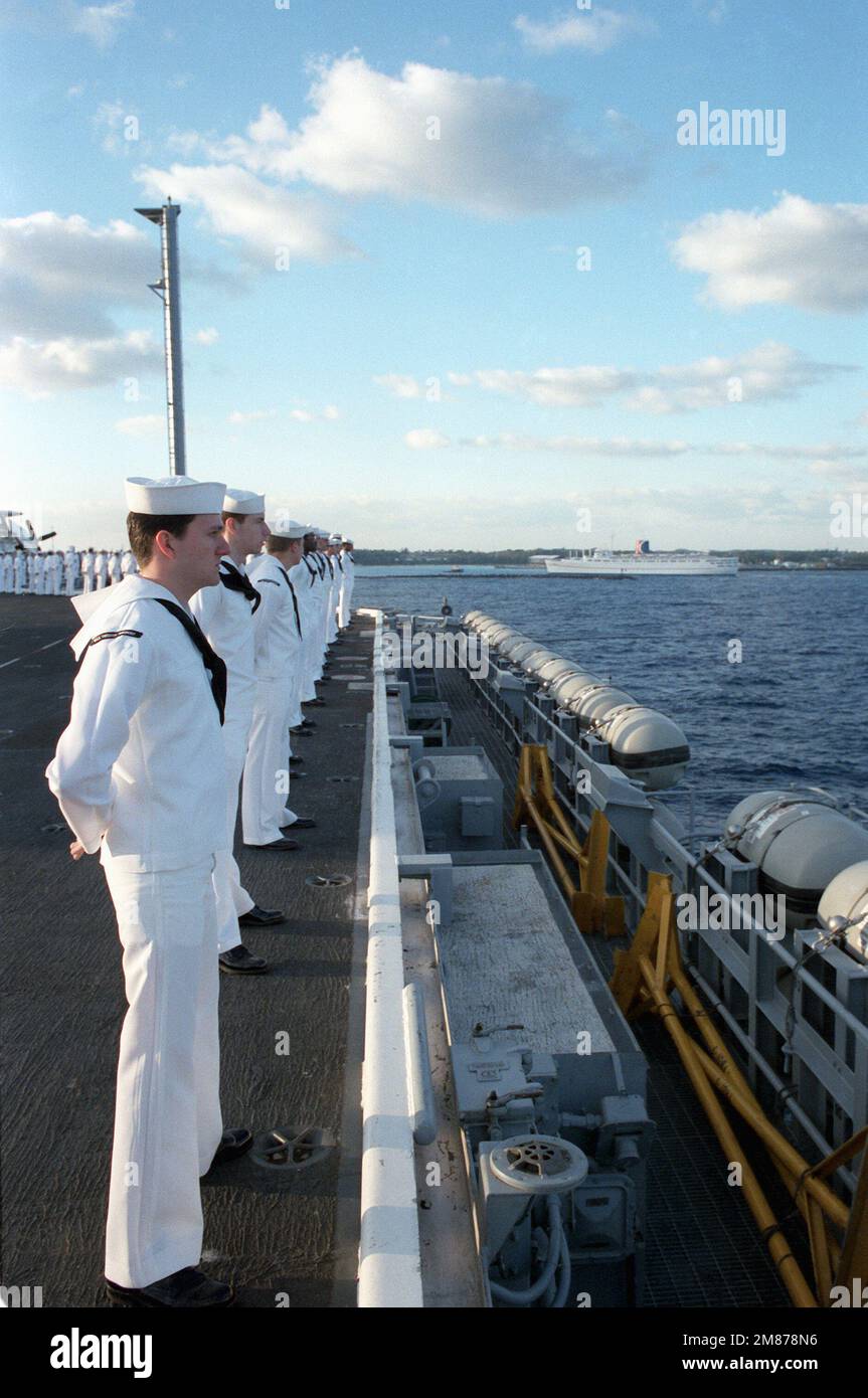 Sailors man the rail as the nuclear-powered aircraft carrier USS ...