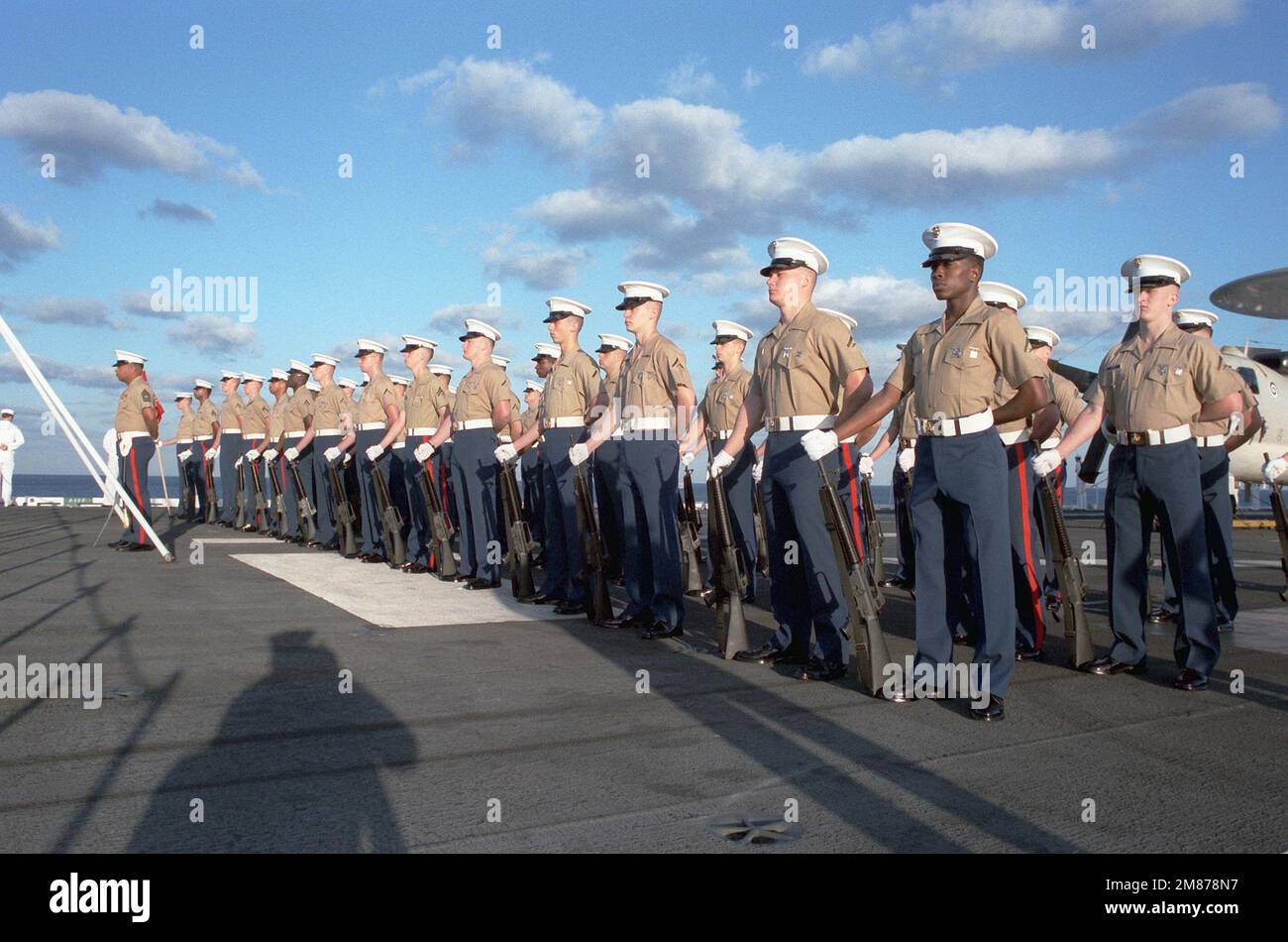 Members of the ship's Marine detachment stand in formation at parade ...