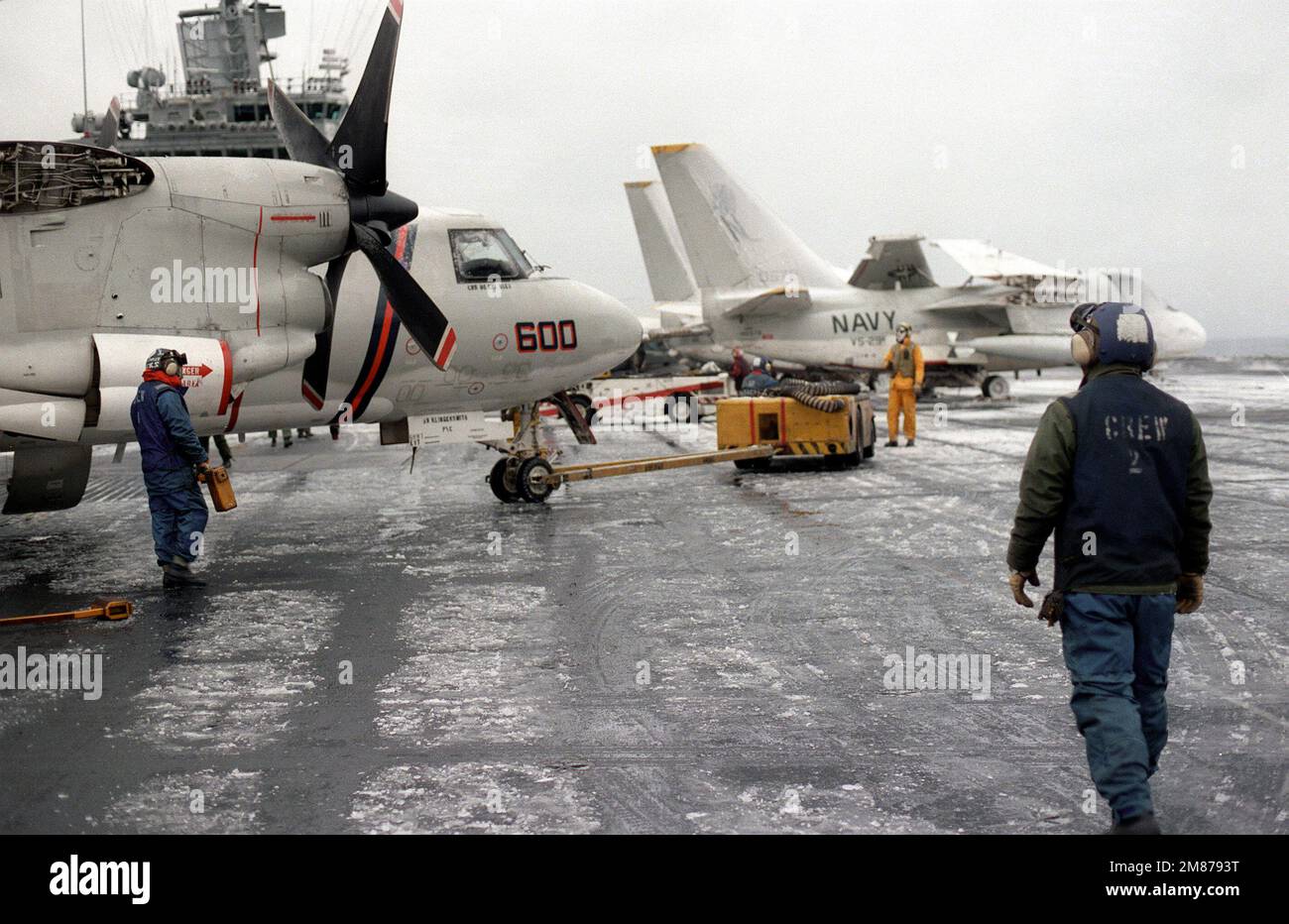 An MD-3A tow tracter is used to tow an E-2C Hawkeye aircraft across the ...