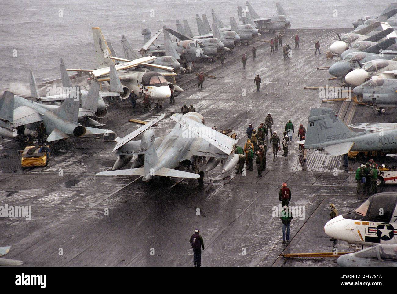 Flight deck crewmen stand by an EA-6B Prowler aircraft parked on the ...