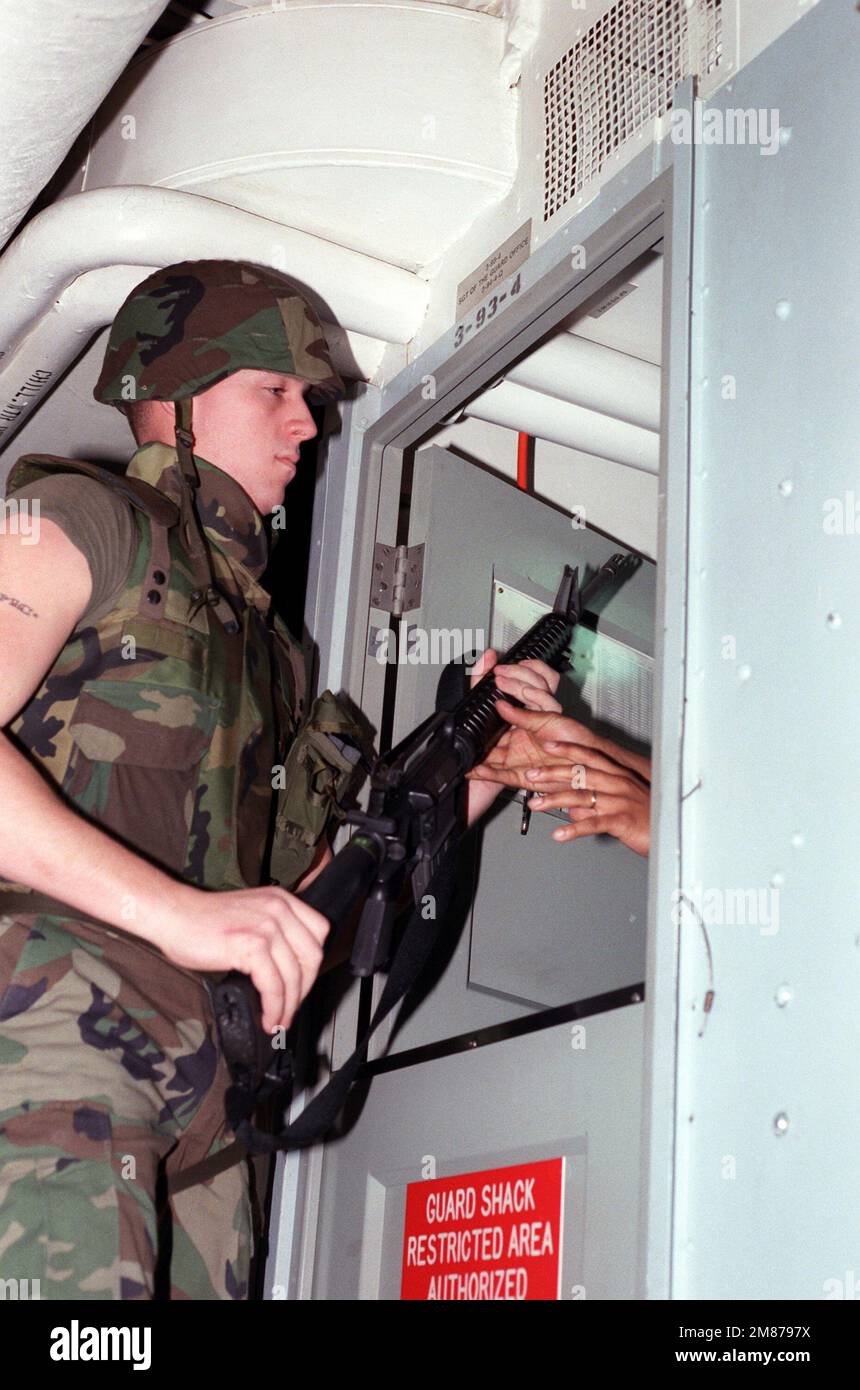 A Marine returns his M16A2 rifle to the guard shack aboard the nuclear ...