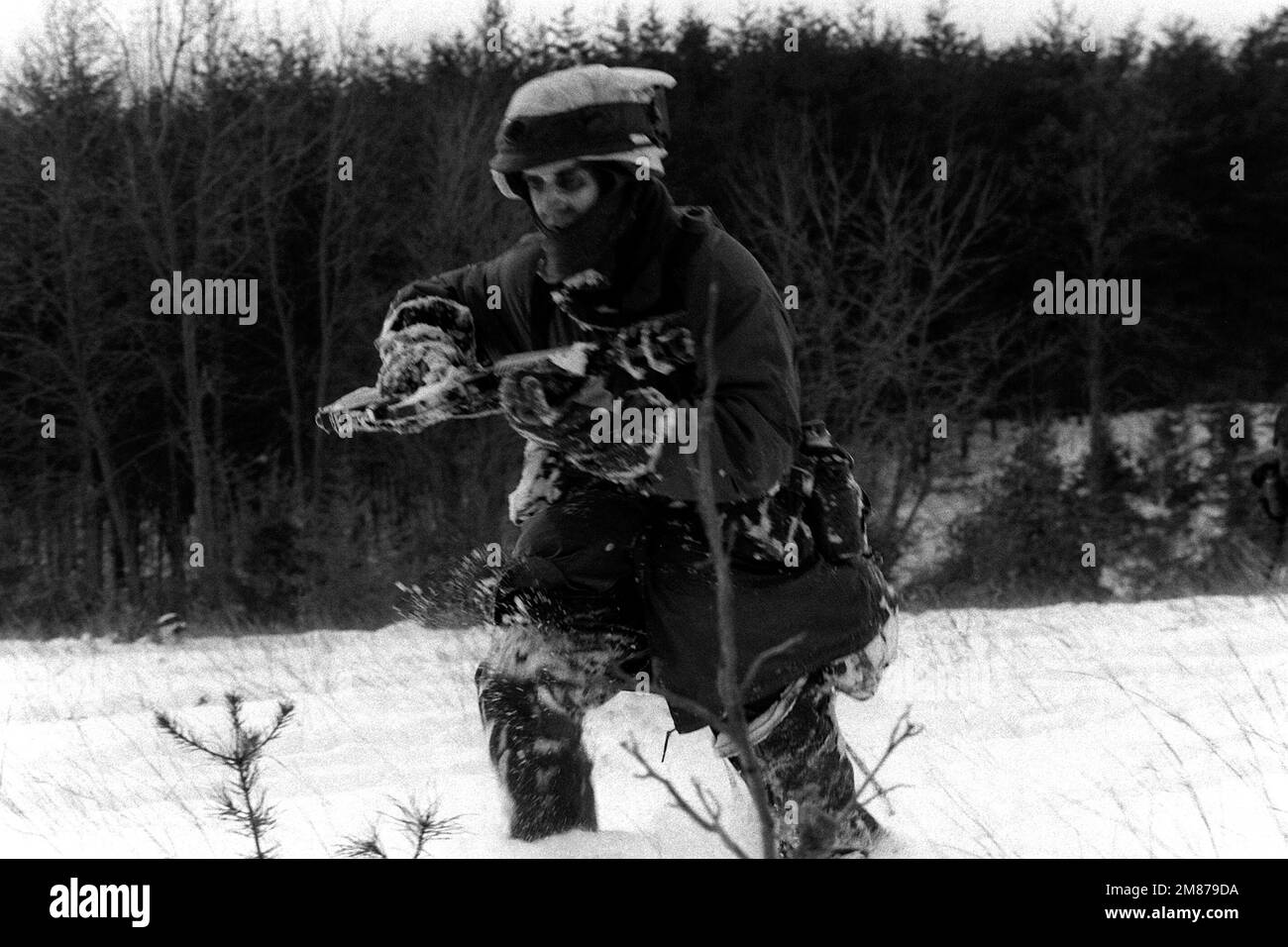 A lieutenant charges through the snow with his M-16A2 rifle during the ...