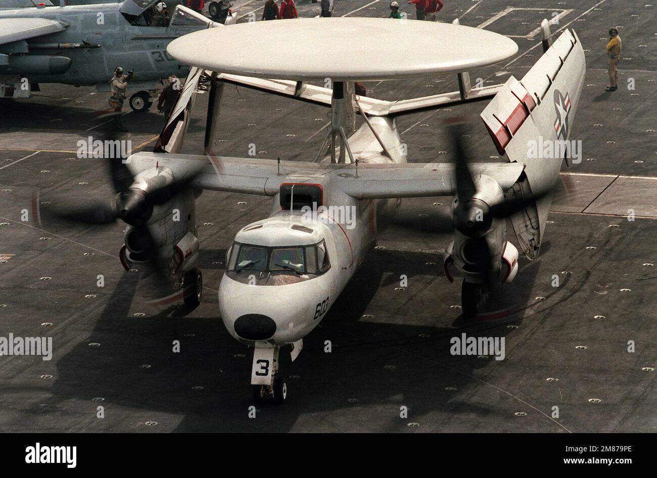 An E-2C Hawkeye aircraft taxis along the flight deck of the aircraft ...