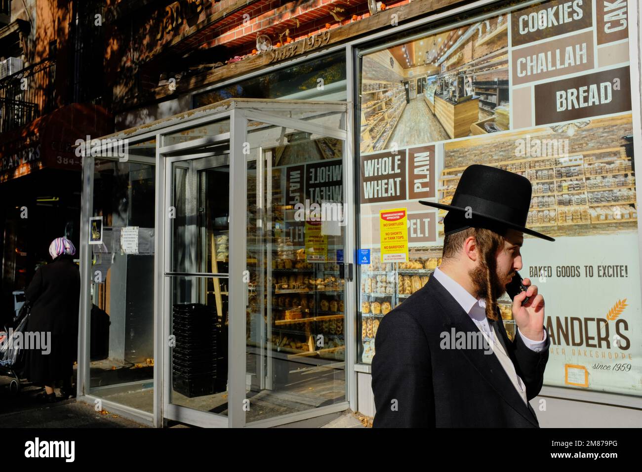 An orthodox Jewish man talking on his mobile phone on Lee Avenue ...