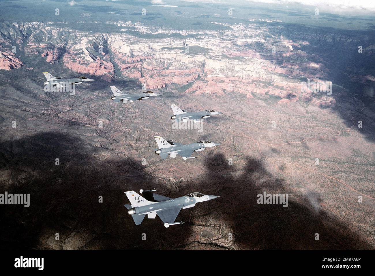An air-to-air right side view of a flight of five F-16 "Fighting ...