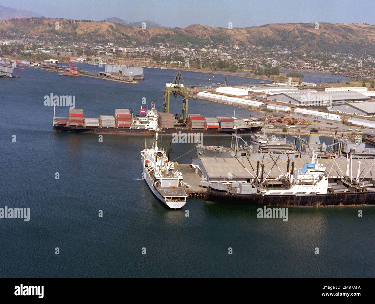 An aerial view of four Military Sealift Command ships moored at the ...