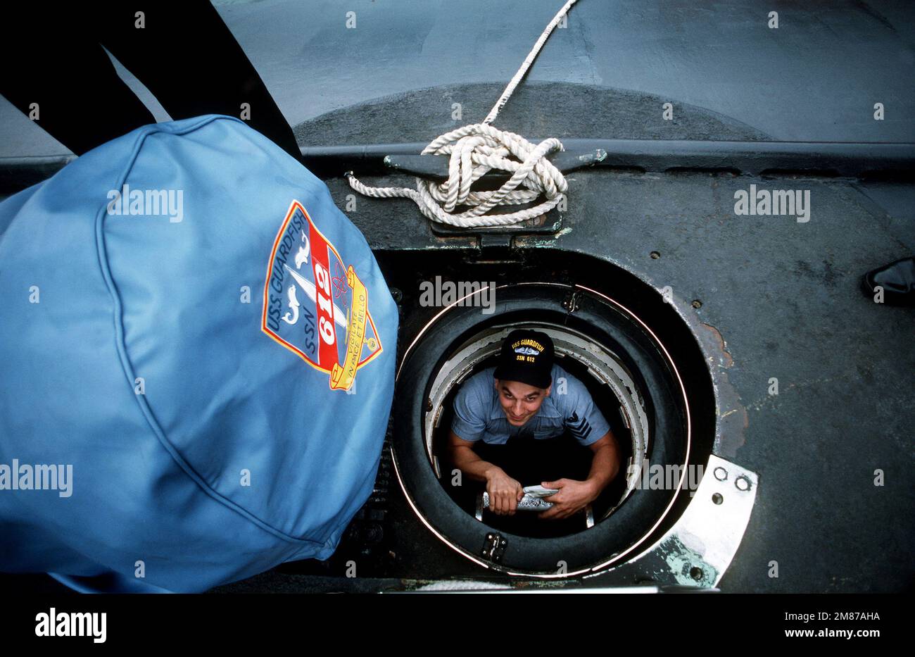 A petty officer climbs up a ladder to the deck of the nuclear-powered ...