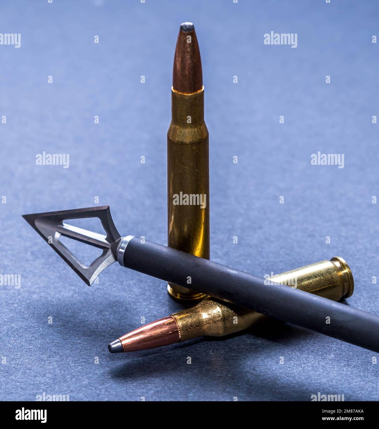 Two 30.06 rifle bullets with a three blade broadhead attached to an ...