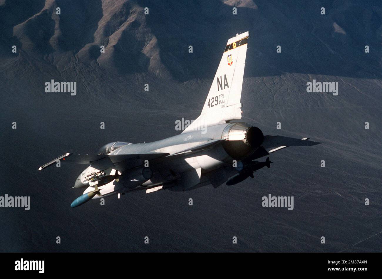 An air-to-air left rear view of an F-16 Fighting Falcon aircraft of the ...
